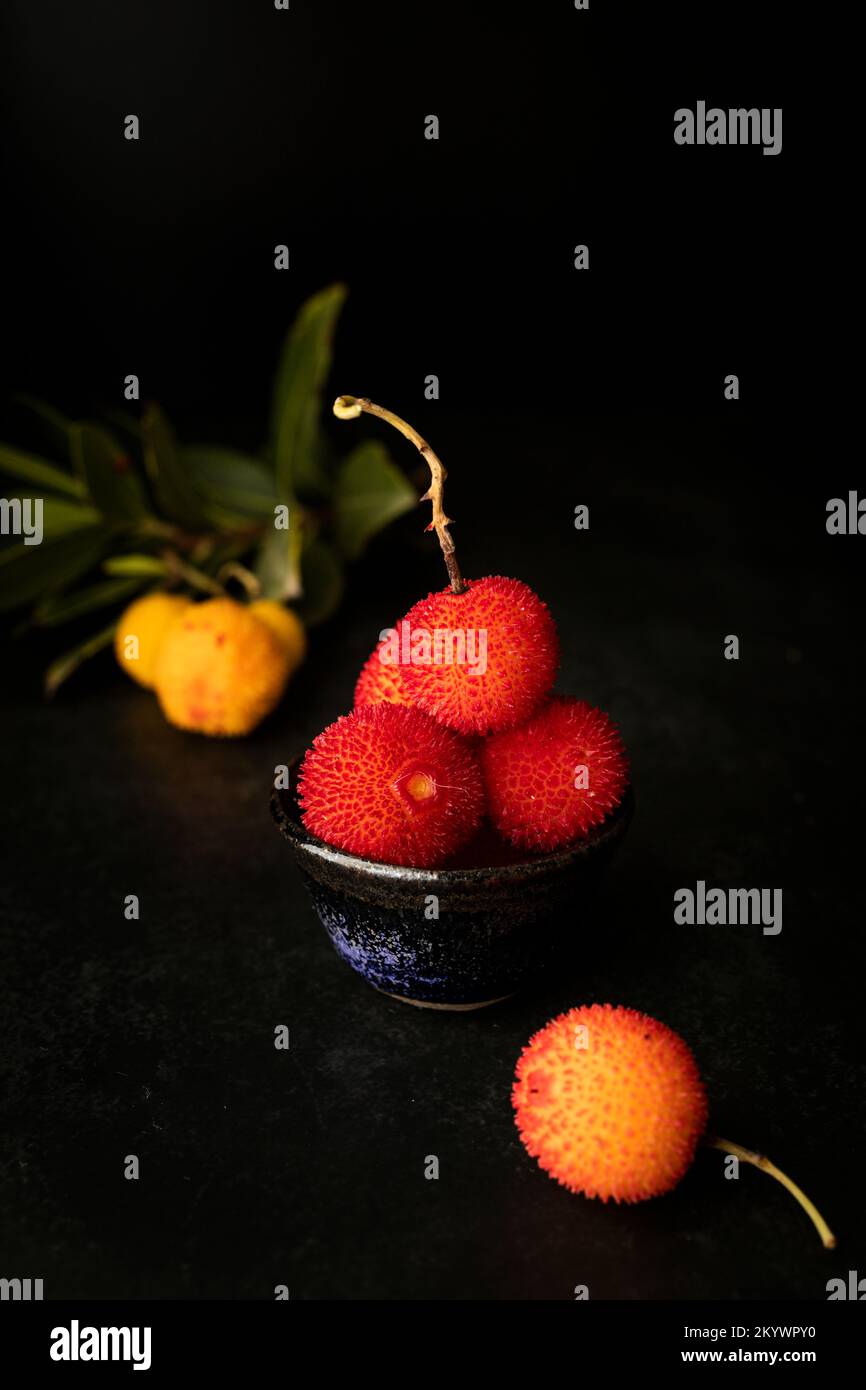 Arbutus, the fruit of the strawberry tree, with a black background ...