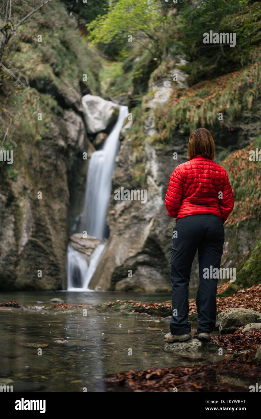 Woman contemplating a waterfall in a forest river Stock Photo - Alamy