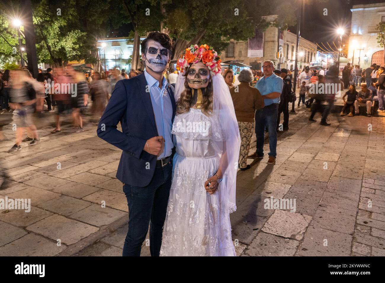 A couple dressed as bride and groom with faces painted to celebrate the ...