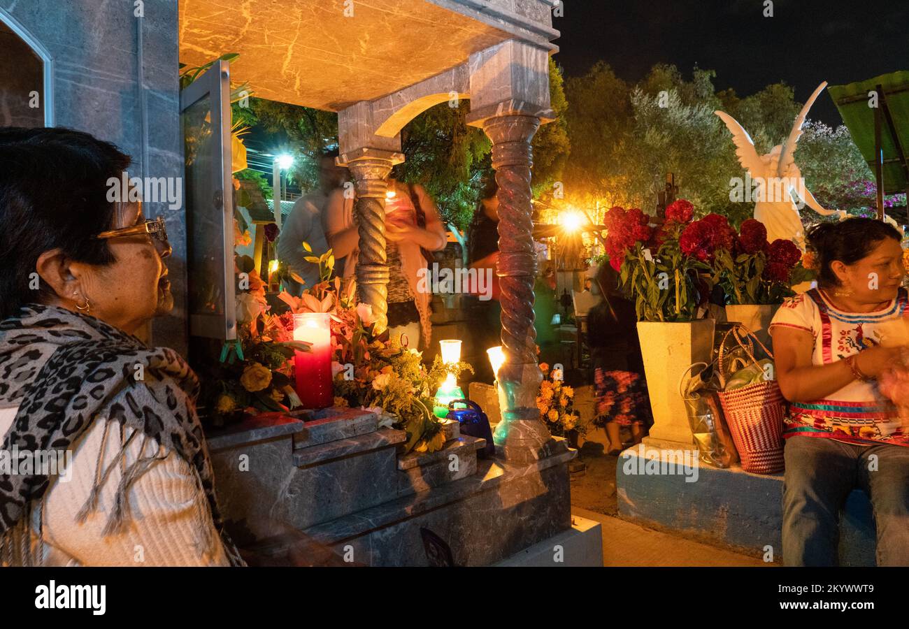 Women sit by a grave in the Xochimilco Cemetery decorated for the Day ...