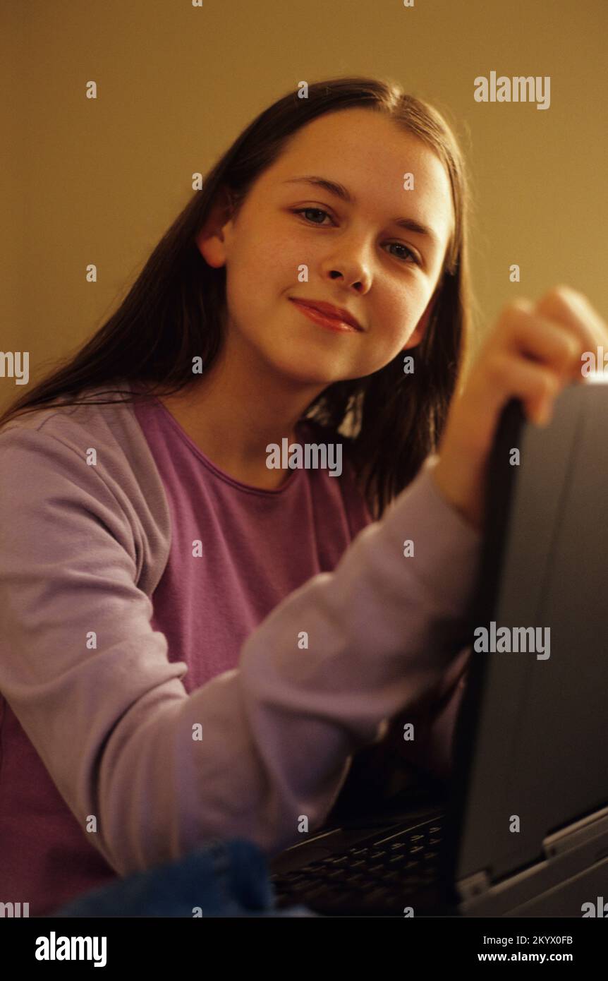 Young girl on computer smiling while studying Stock Photo - Alamy