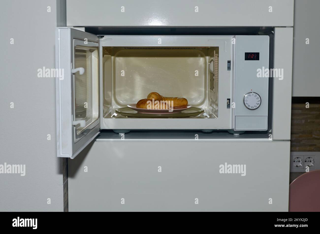 Microwave oven with an open door with croissants in it Stock Photo - Alamy