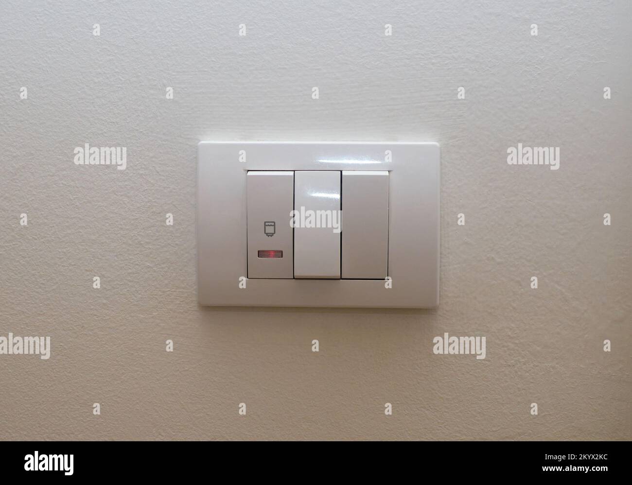 White plastic switch with three switches on a white wall Stock Photo ...