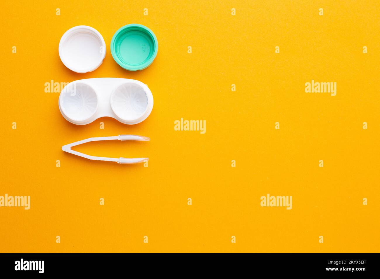 Accessories for contact lenses: a solution container, tweezers. Yellow ...