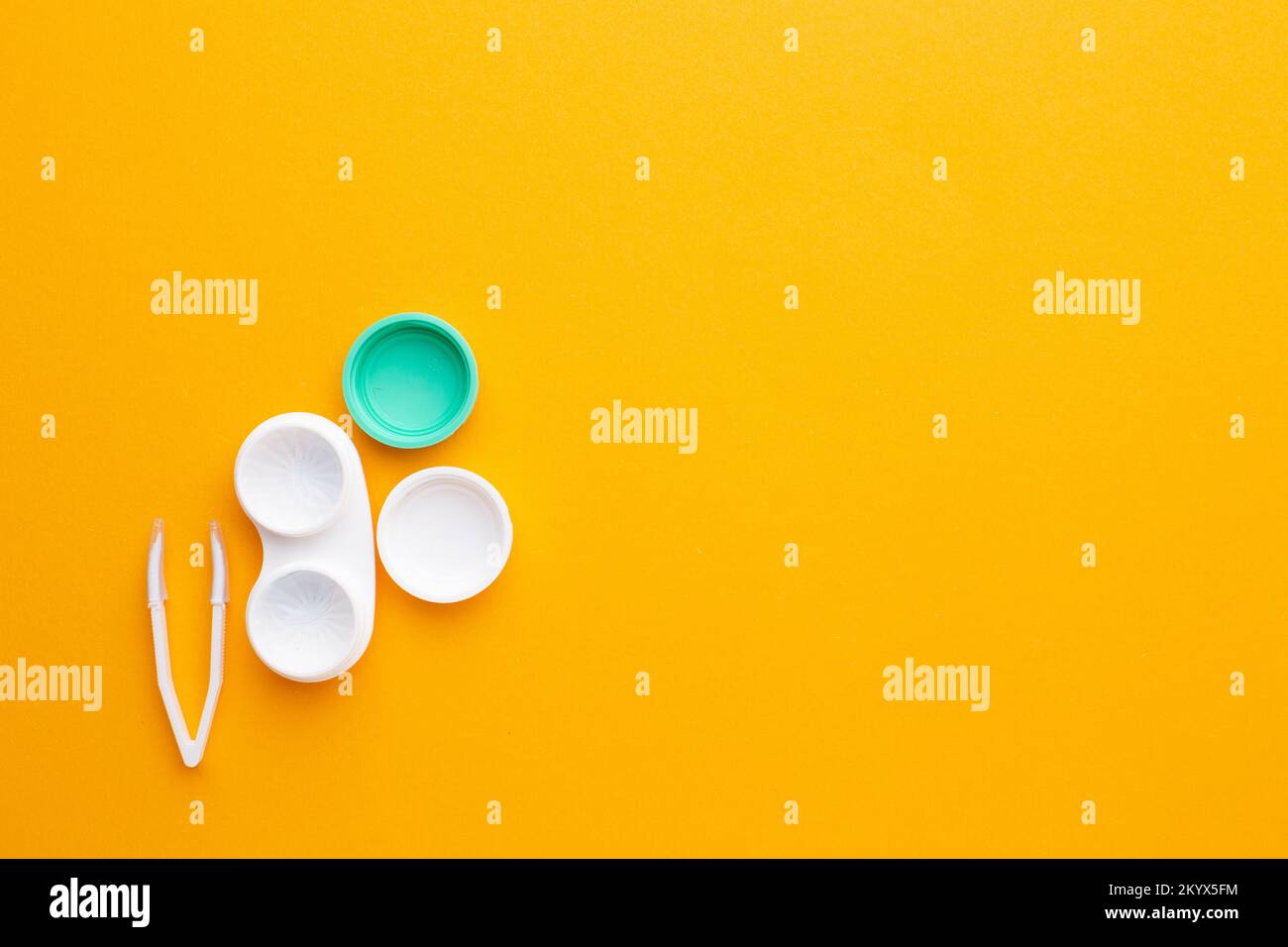 Accessories for contact lenses: a solution container, tweezers. Yellow ...