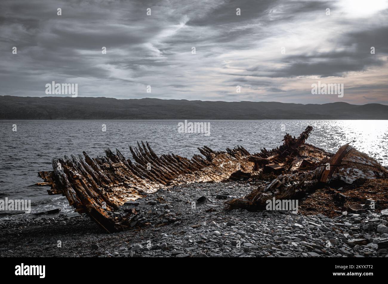 Gloomy view of an old wrecked ship on the shore of Rybachy Peninsula ...