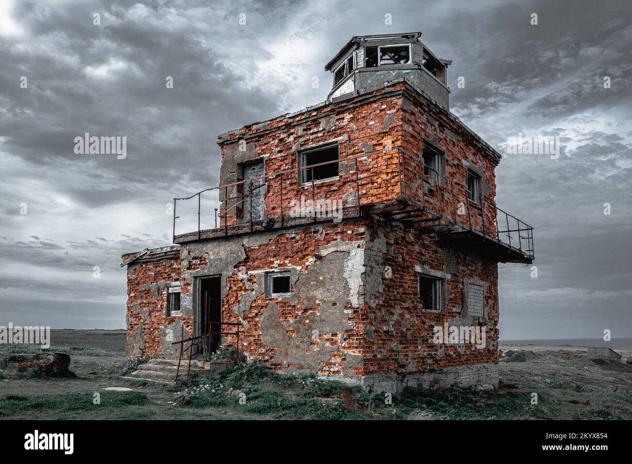 Gloomy image of the abandoned beacon against stormy skies. Rybachy ...