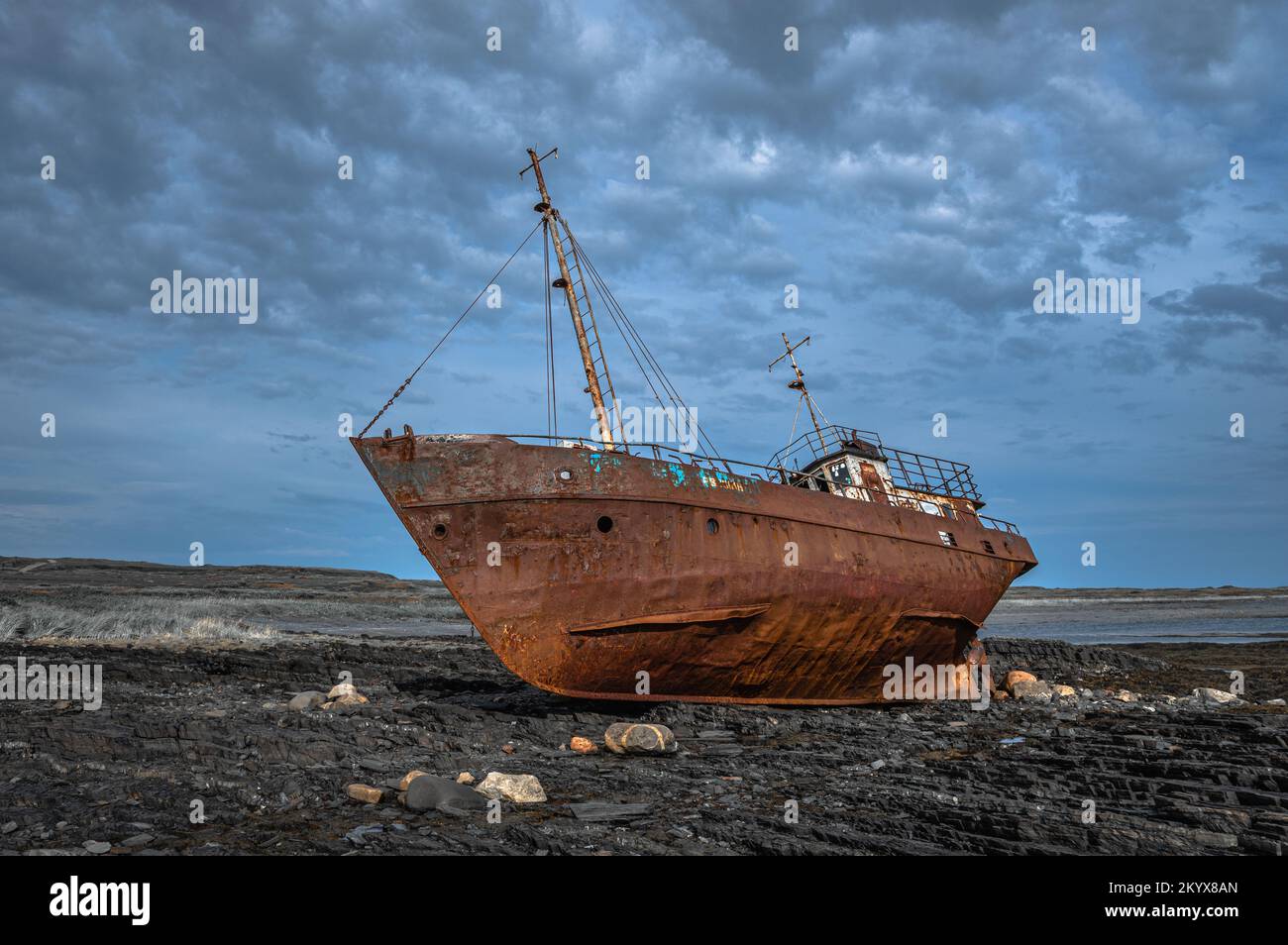 Picturesque view of a sunken rusty ship thrown on the shore. Rybachy ...