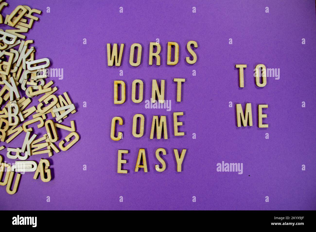 purple background with a pile of wooden capital letters spilling into ...