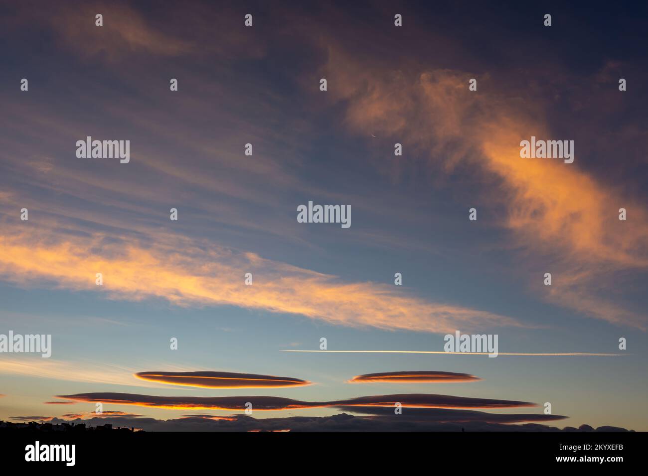 Lenticular clouds and cirrus clouds in the sky with the moon at dawn ...