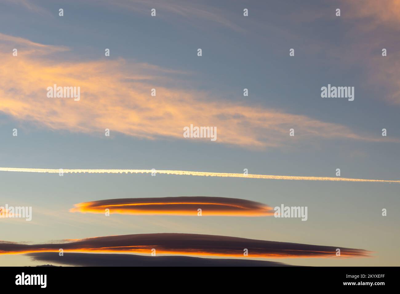 Lenticular clouds and cirrus clouds in the sky with the moon at dawn ...