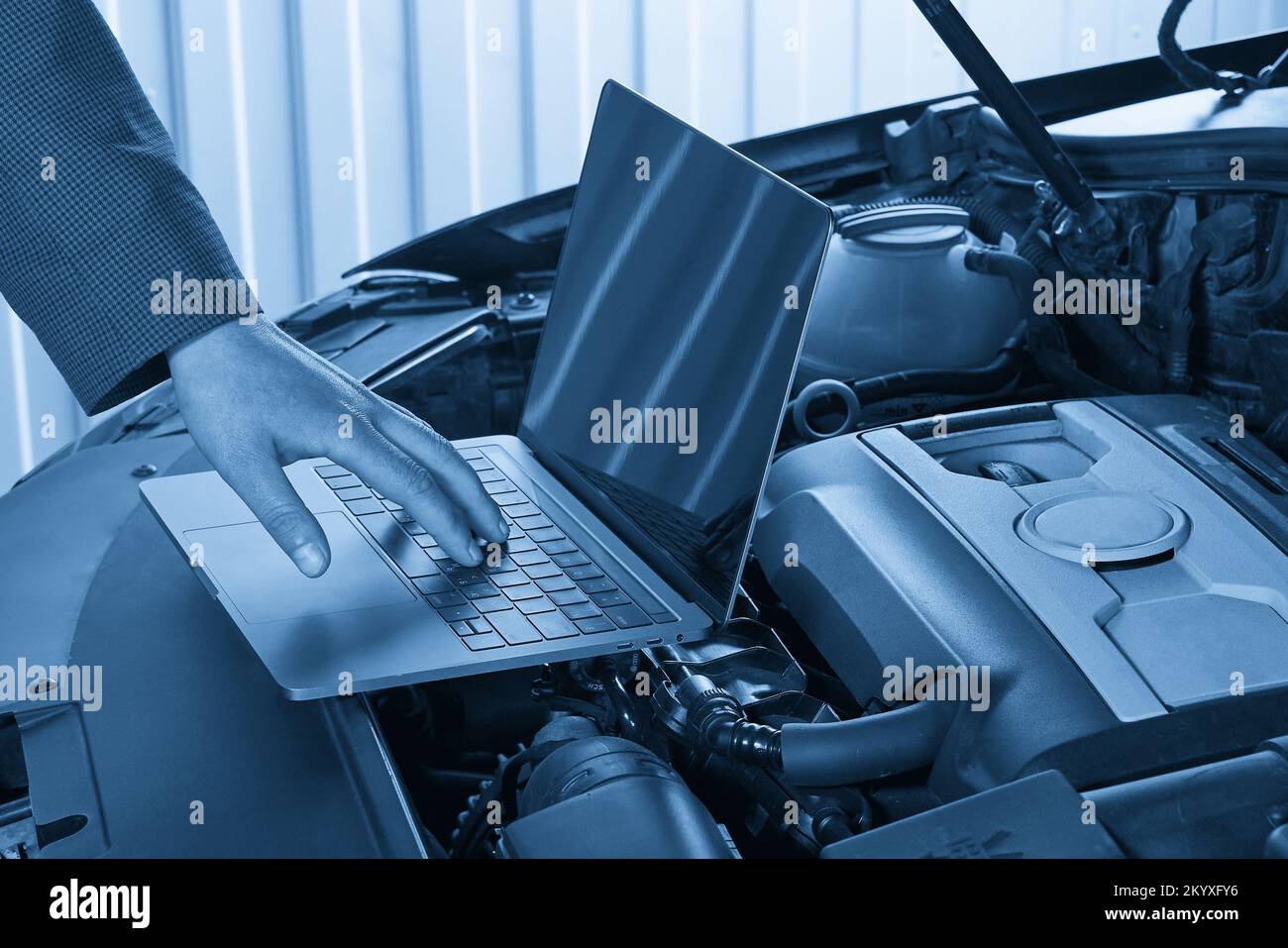 Car mechanic using computer in auto repair shop Stock Photo - Alamy