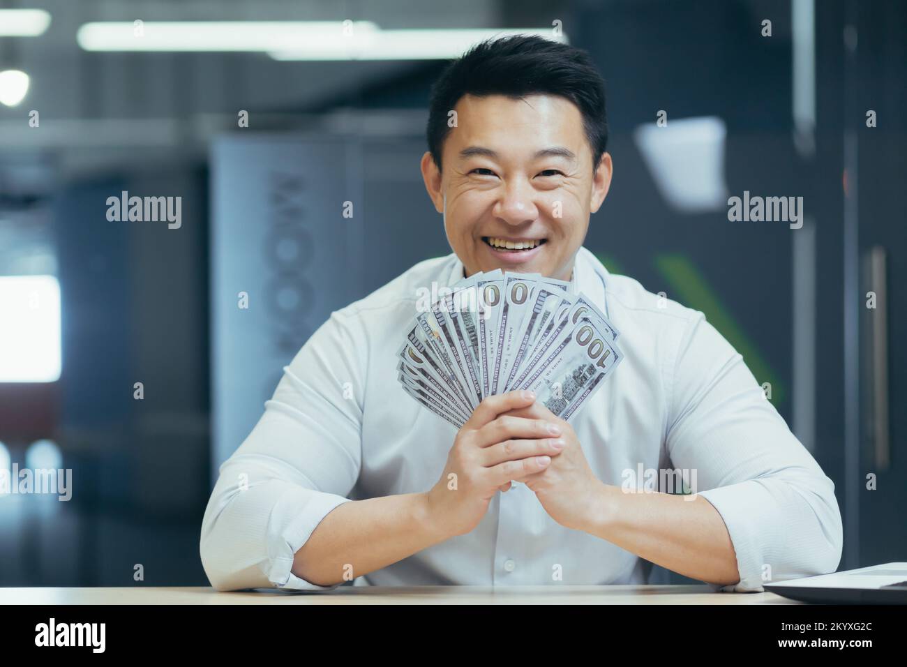 Portrait of a young Asian business man, an office worker sitting at a ...