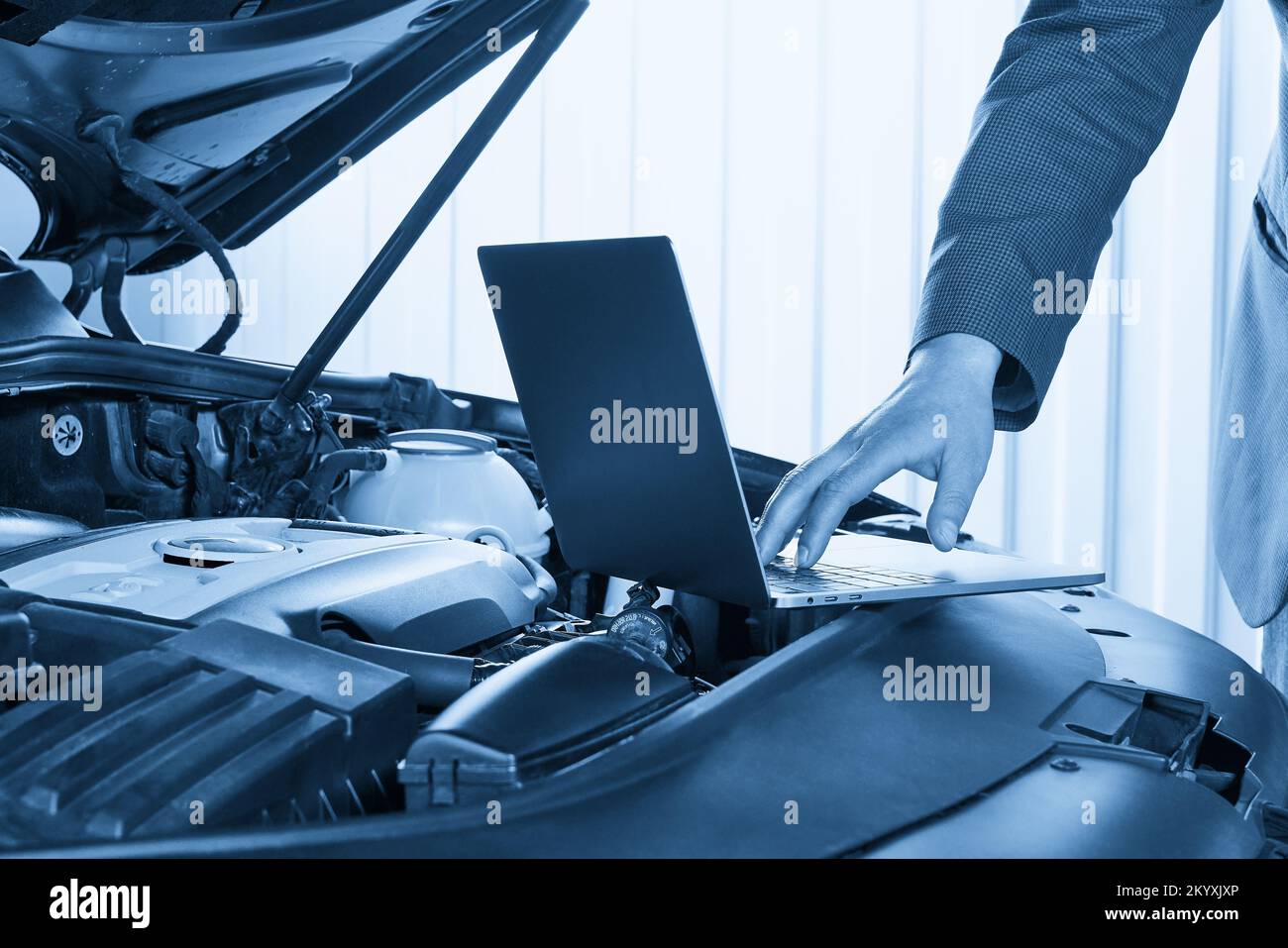 Car mechanic using computer in auto repair shop Stock Photo - Alamy
