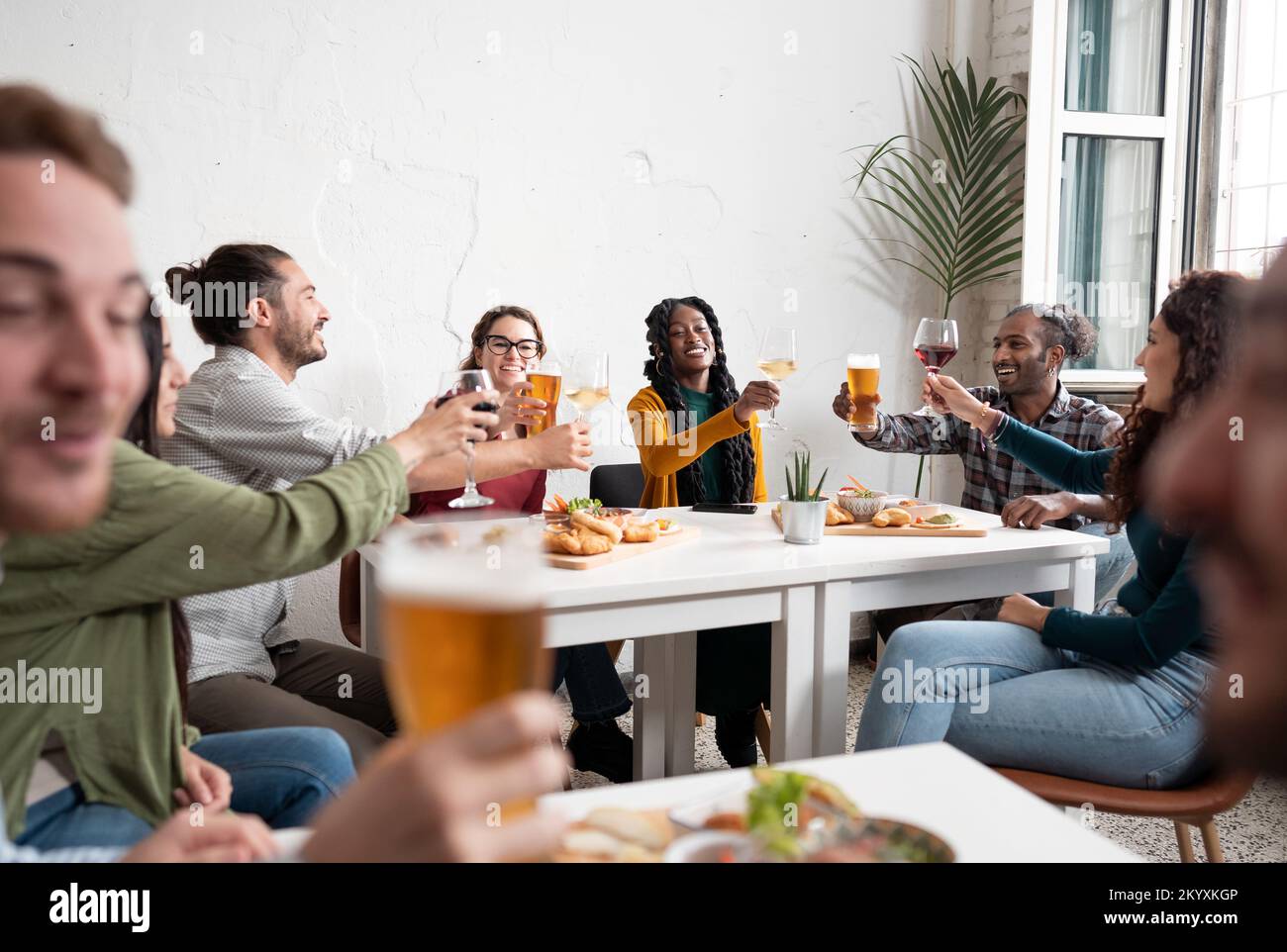 Multiracial group of friends having fun at pub drinking wine and beer ...