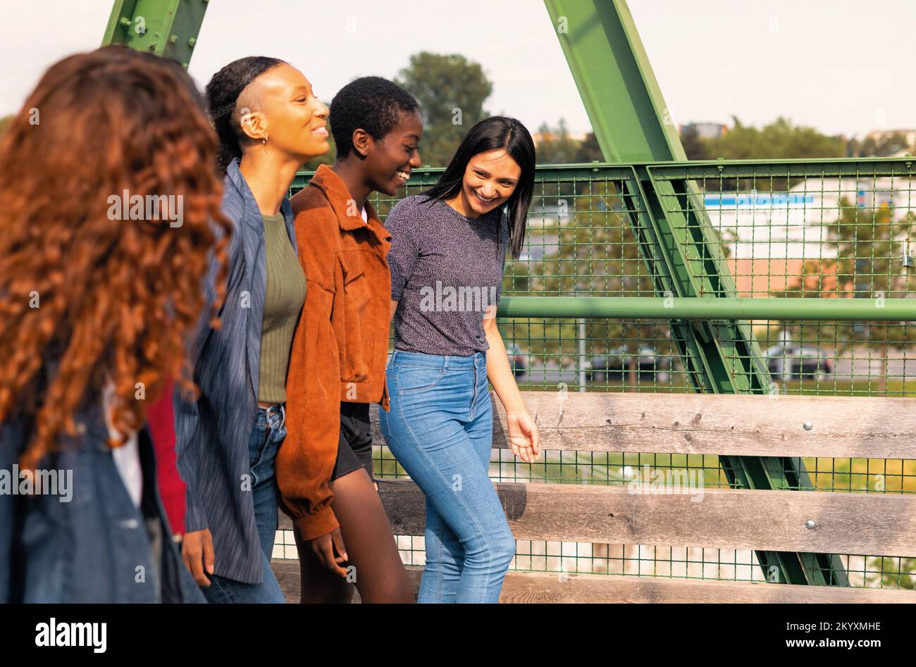 Group of happy girls walking over the bridge and joying in sunset Stock ...