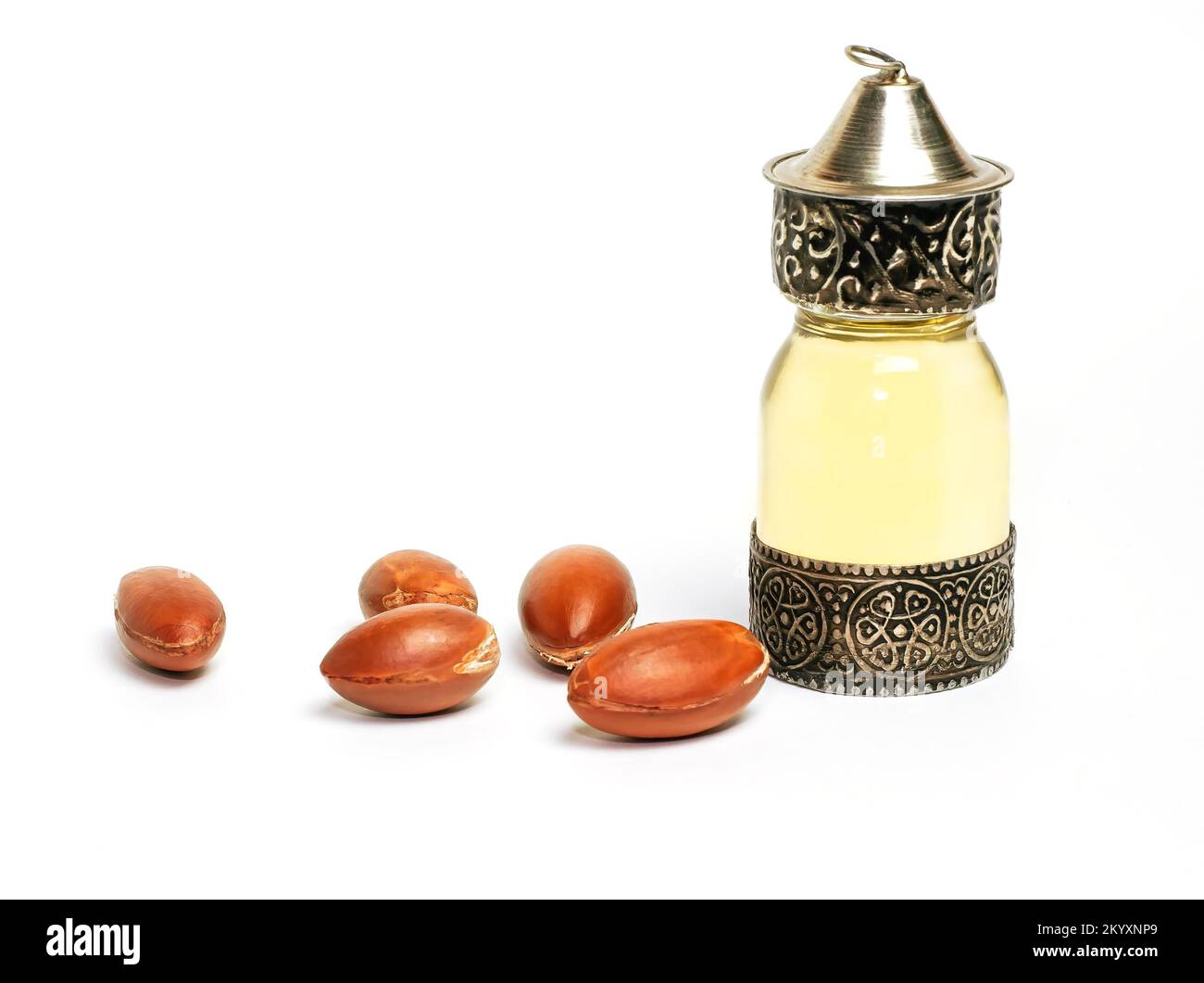 Argan oil in a oriental glass and metal bottle and argan nuts with ...