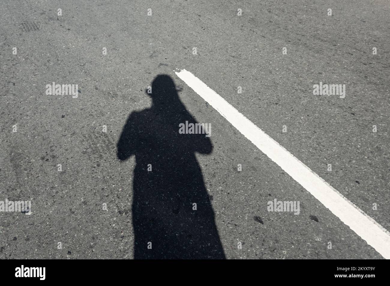 Street, asphalt, white strip and the photographers shadow. Salvador ...