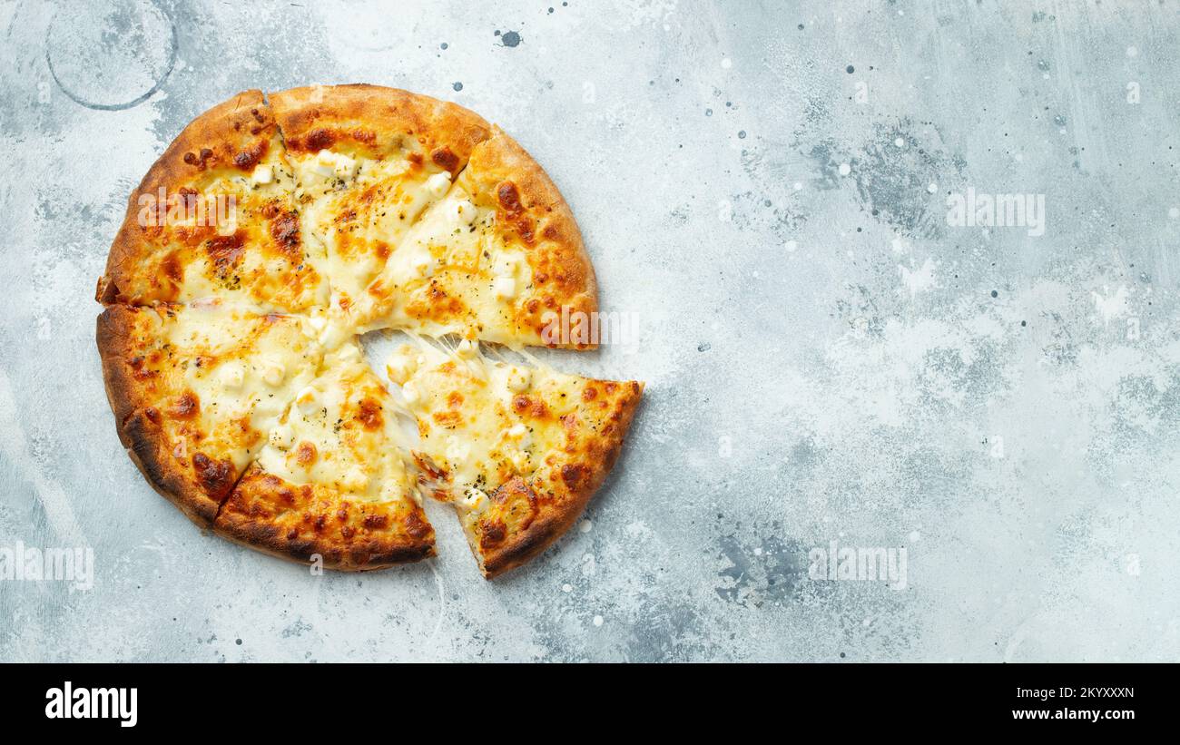 Italian pizza four cheeses with stretching cheese and basil on a light ...