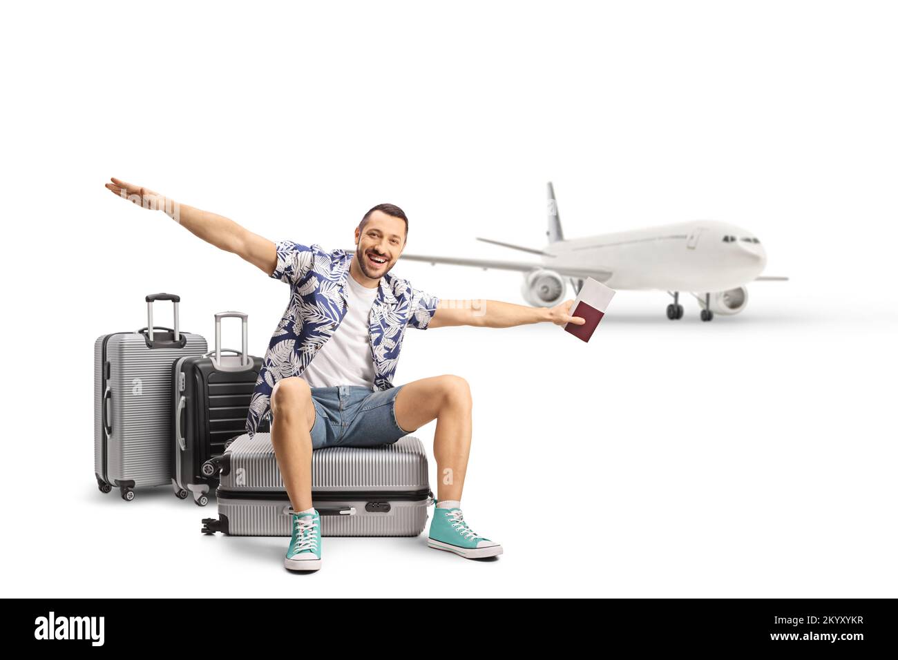 Airplane and a male tourist sitting on a suitcase and spreading arms to ...