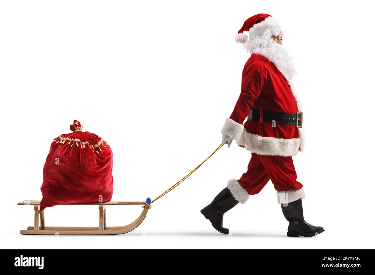 Full length profile shot of santa claus pulling a wooden sled with a ...