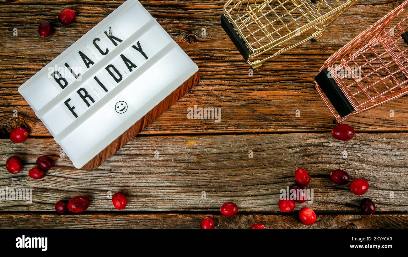 Light box with black Friday text and push cart on rustic table desk top ...