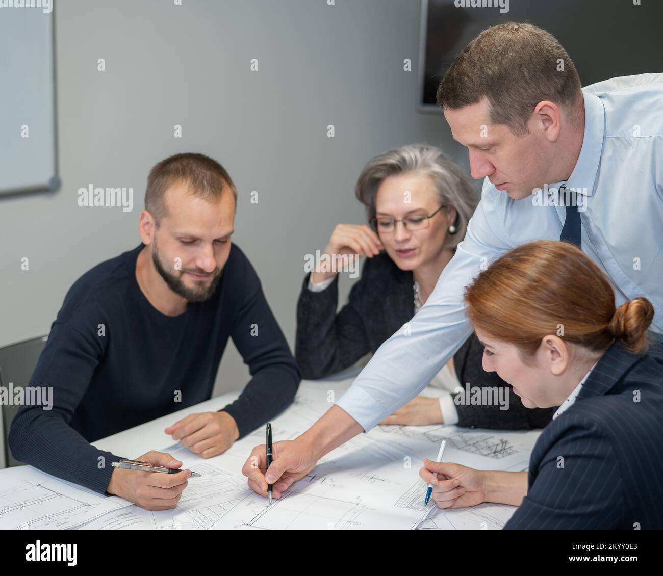 The boss gives instructions to three employees in the office conference ...