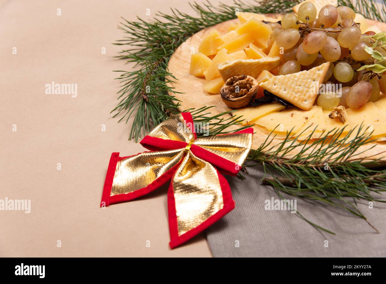 Christmas snacks on rustic wooden board with golen boa over paper ...