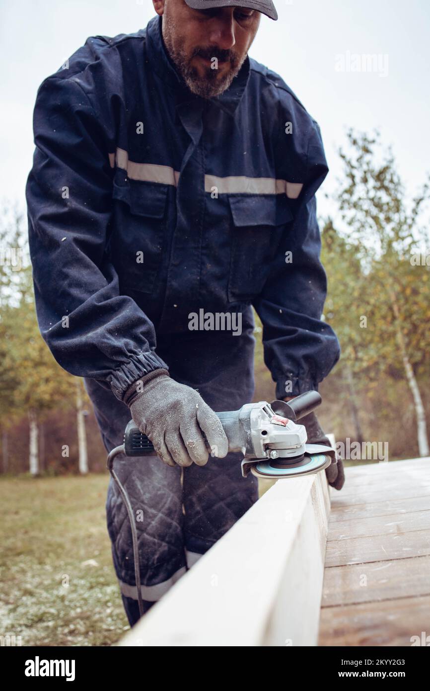 Man using electric grinder to polish wood plank Stock Photo - Alamy
