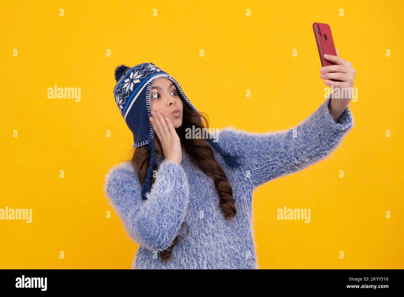Kids selfie. Close-up portrait of cute teen girl in winter knitted hat ...