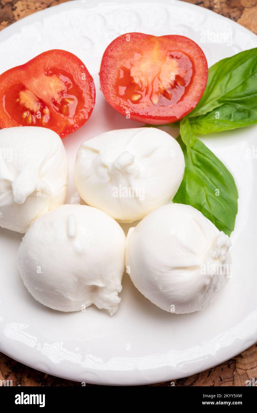 Eating of fresh handmade soft Italian cheese from Puglia, white balls ...