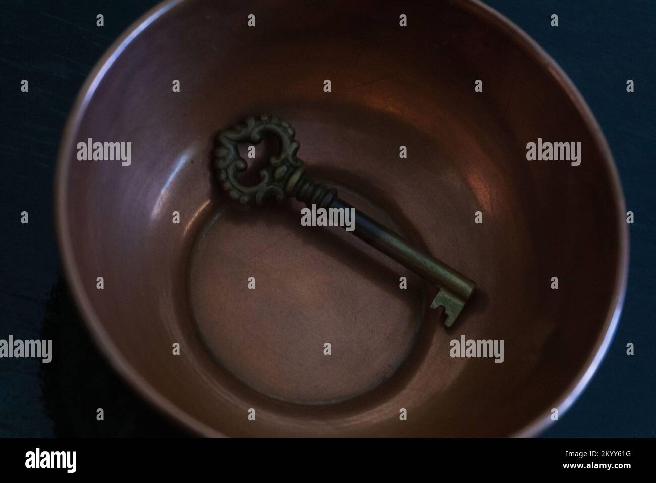 Antique metal key in antique copper bowl Stock Photo - Alamy