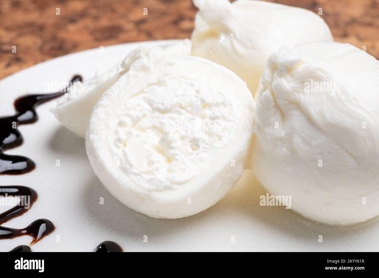 Eating of fresh handmade soft Italian cheese from Puglia, white balls ...