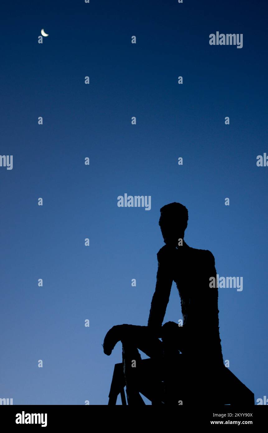 photography of a sculpture lonely man in thinking position under the ...