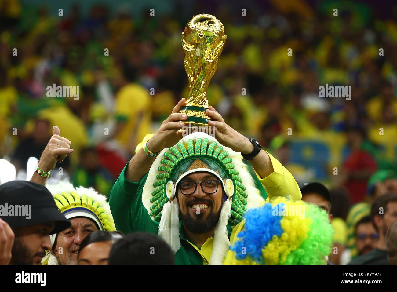 Doha, Qatar. 02nd Dec, 2022. A Brazil fan lifts a replica World Cup ...