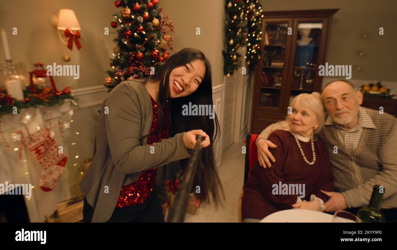 Asian woman with selfie stick records video for blog, shows her family ...