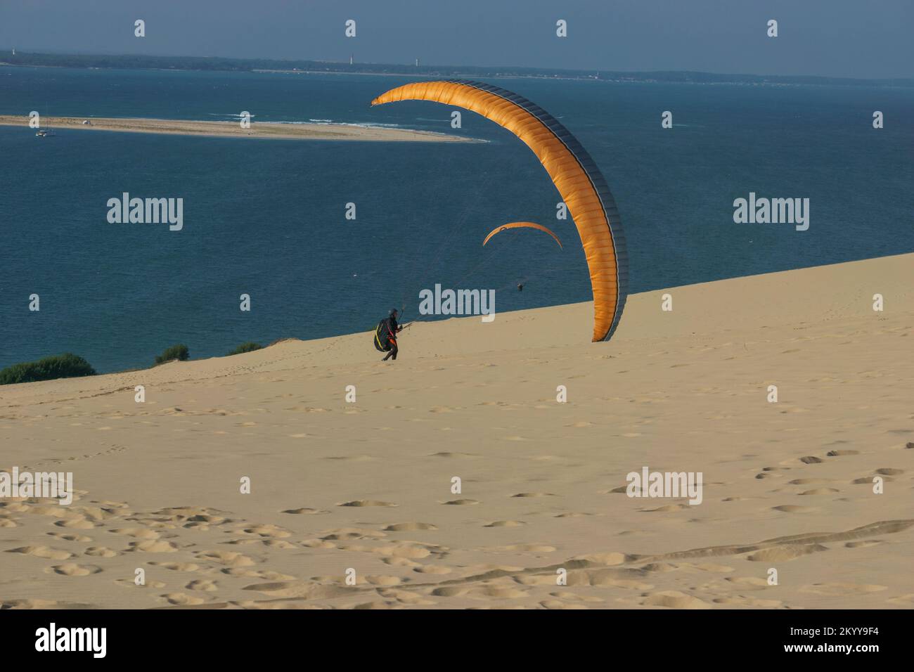 Single paraglider with parachute at the dune of Pilat on a sunny day ...