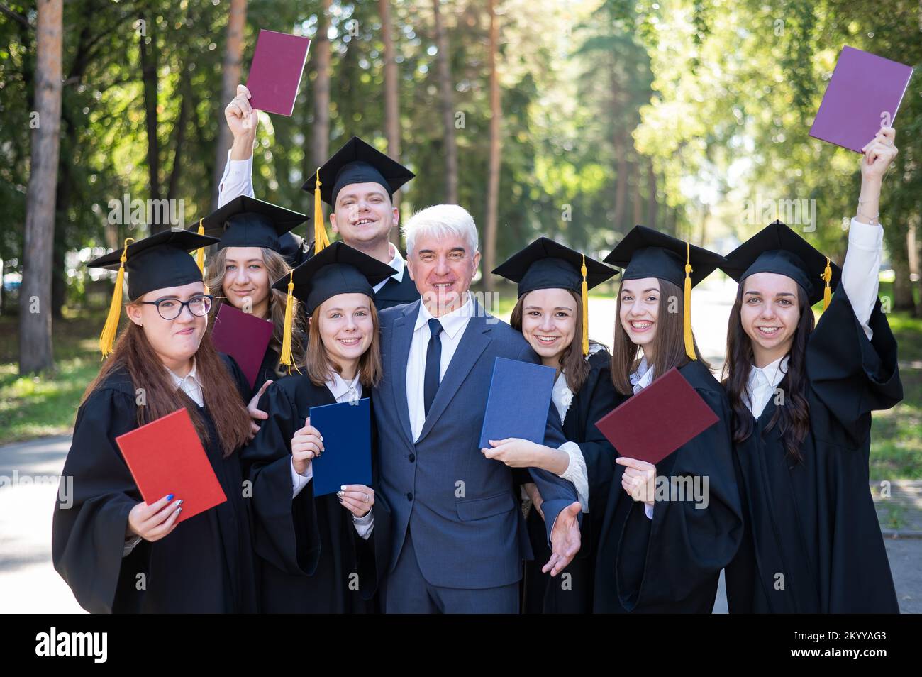 University professor and seven graduates rejoice at graduation Stock ...