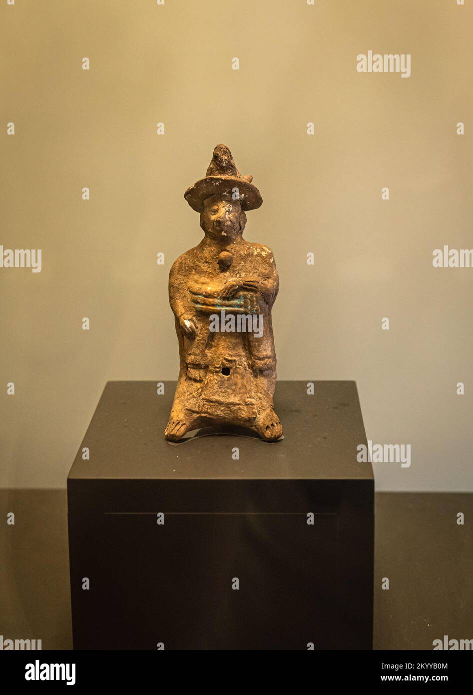 Mayan ceramic figurine of a man with a hat, holding his belt. Late ...