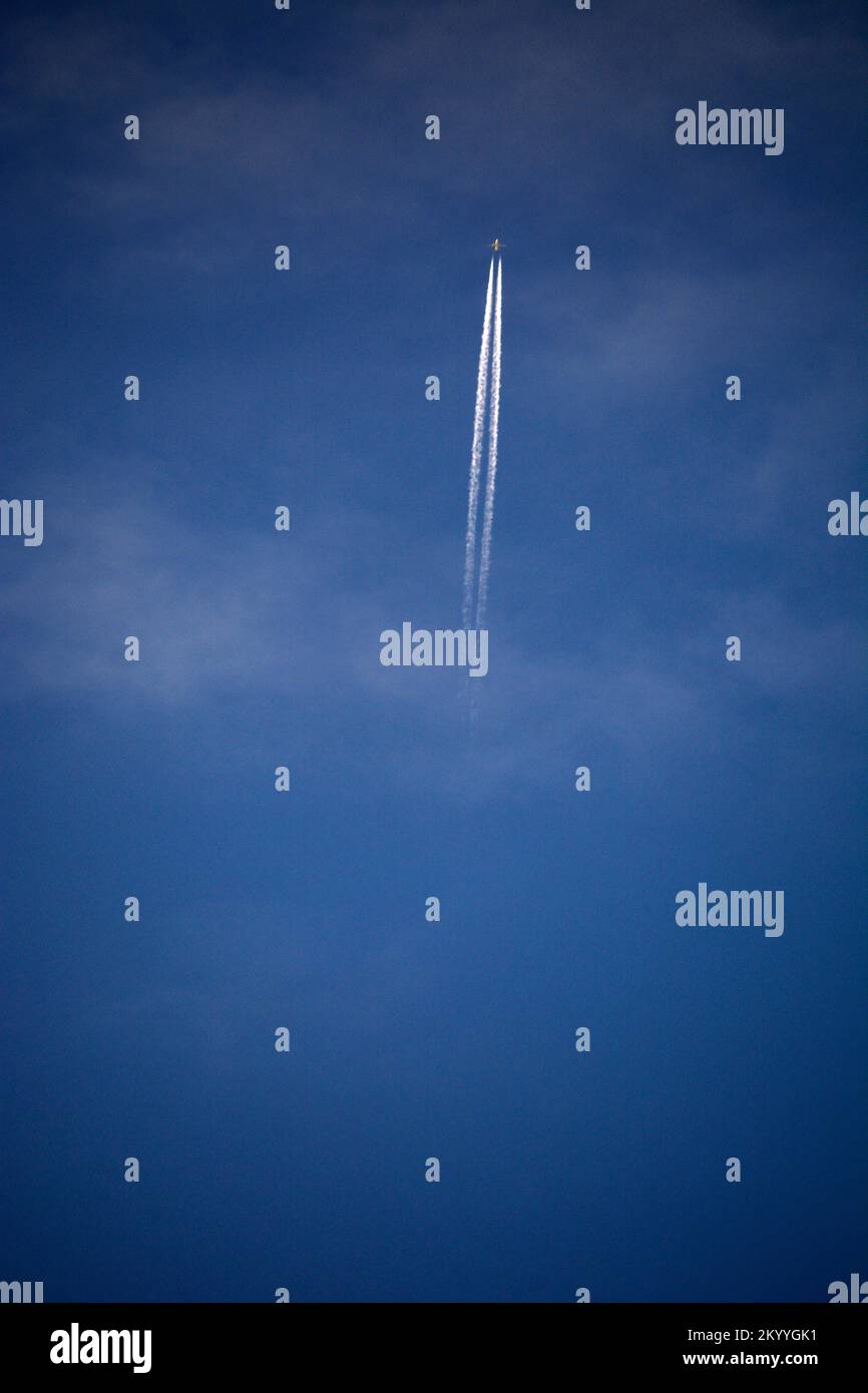 A commercial jet aircraft leaves a contrail as it flies high over New ...
