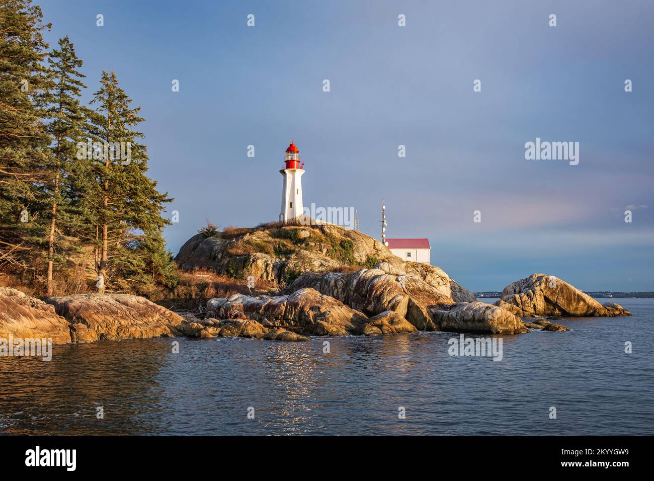 Beautiful view of a Lighthouse on a rocky coast during a cloudy sunset ...