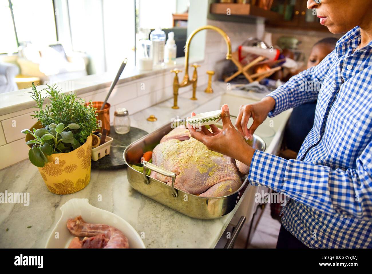 Africa American Woman preparing a large raw turkey for a family ...