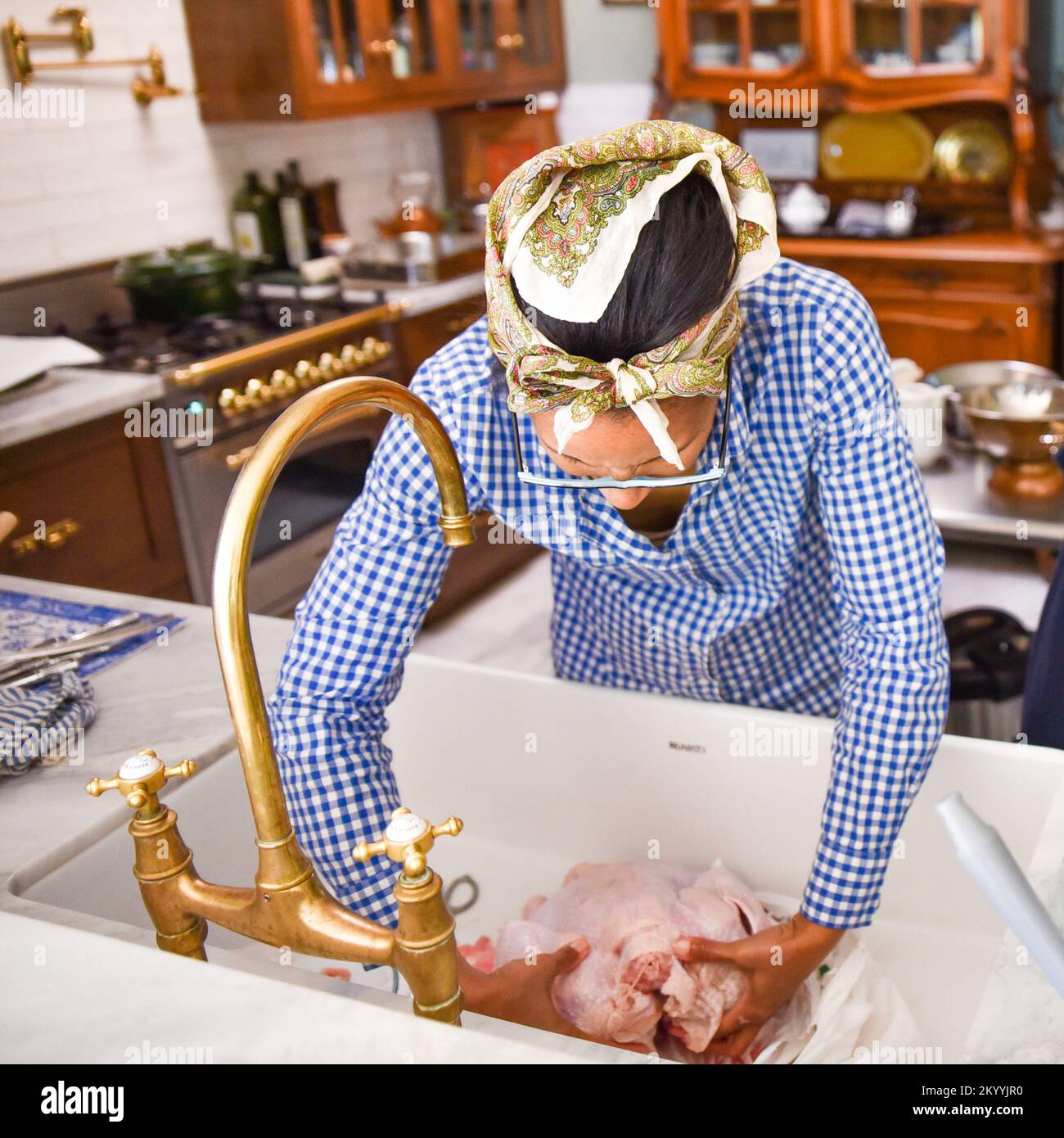 Africa American Woman preparing a large raw turkey for a family ...