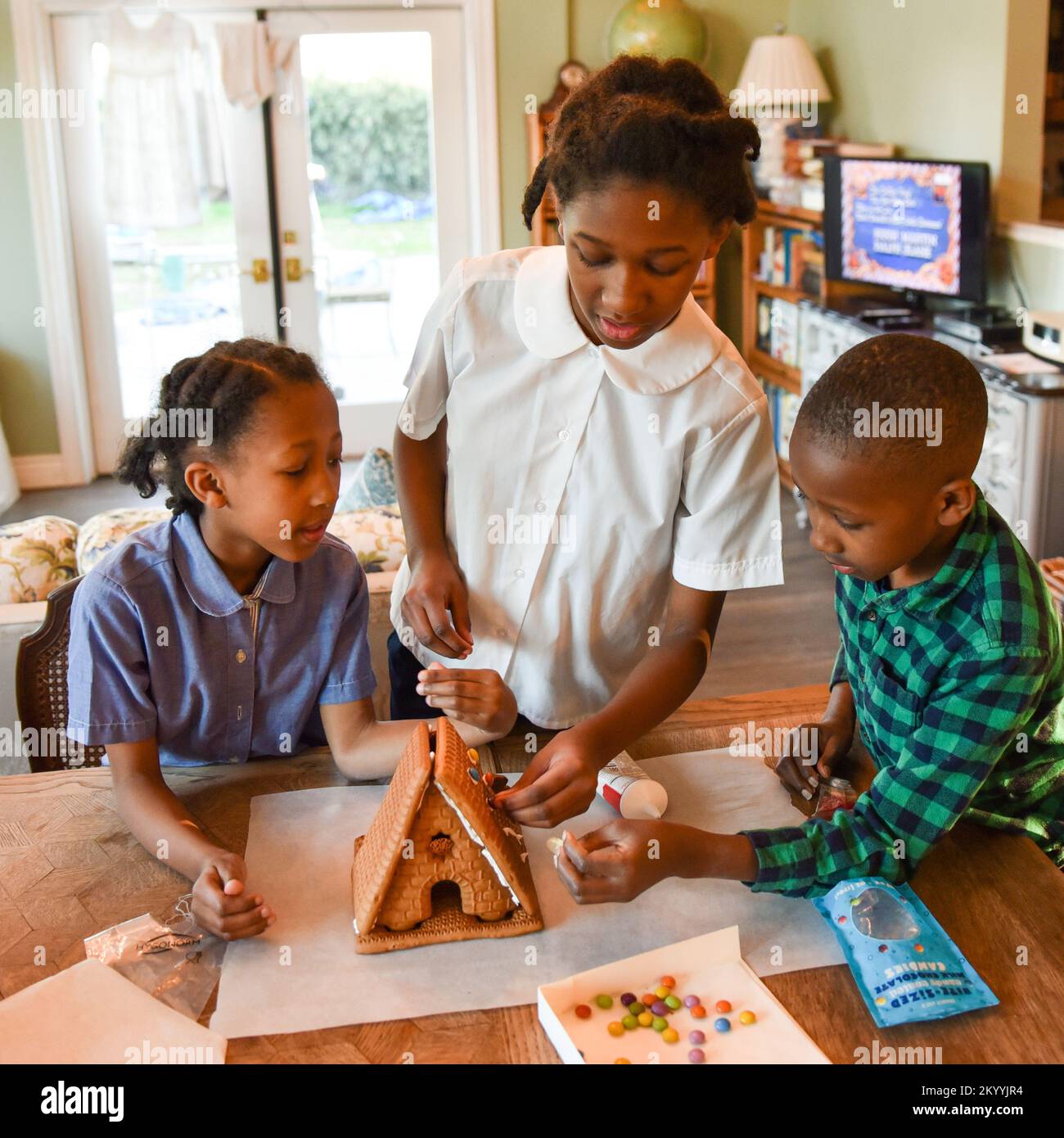 Kids assembling an editable gingerbread house Stock Photo - Alamy