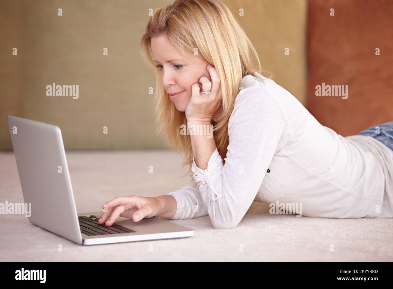 Catching up on social media. A beautiful mature woman working on her ...