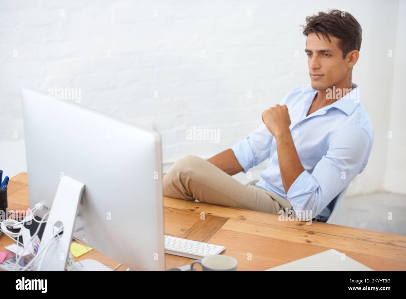 Seriously taking care of business. A handsome young businessman sittin ...