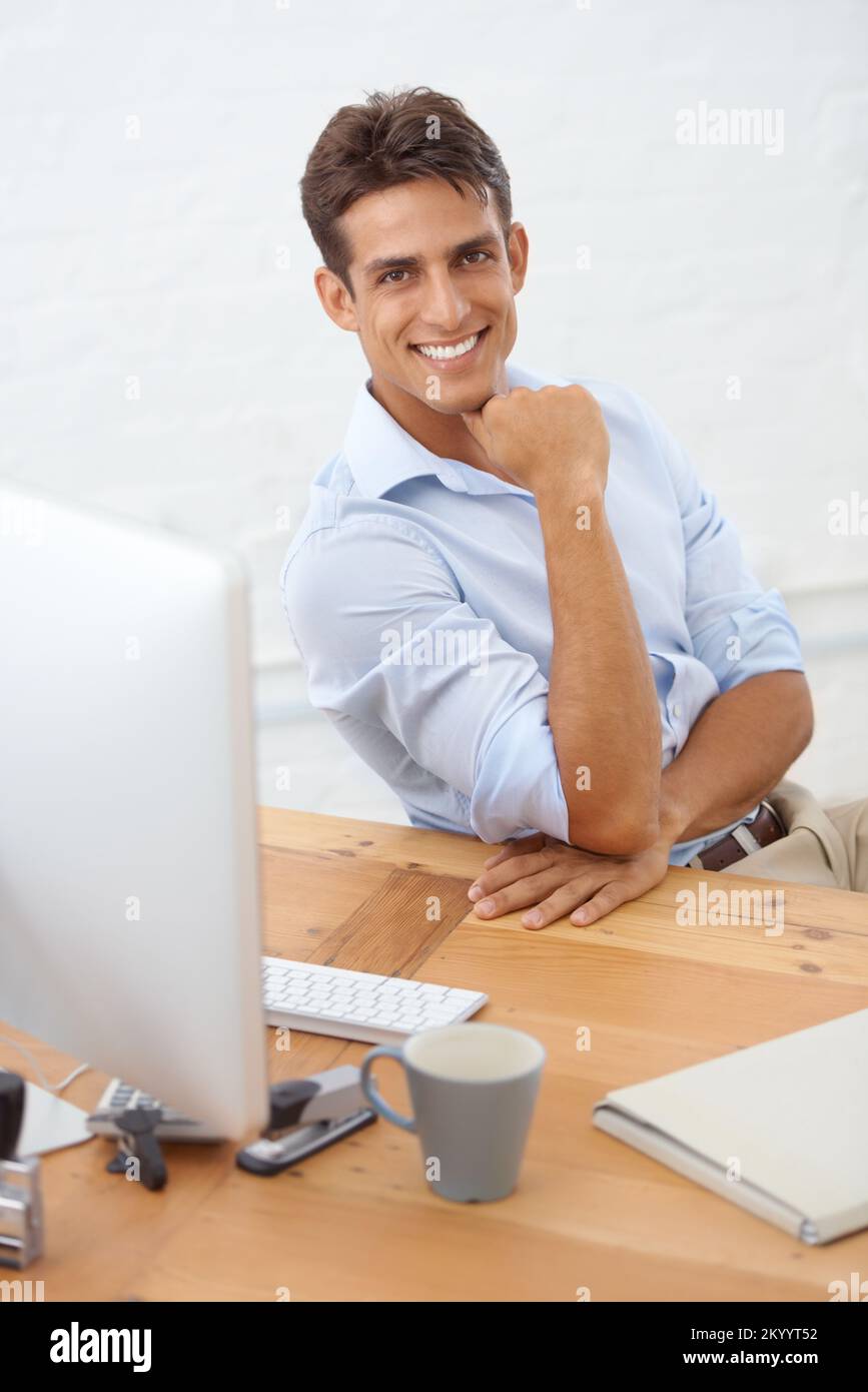 Making technology work for him. A handsome young businessman sitting ...