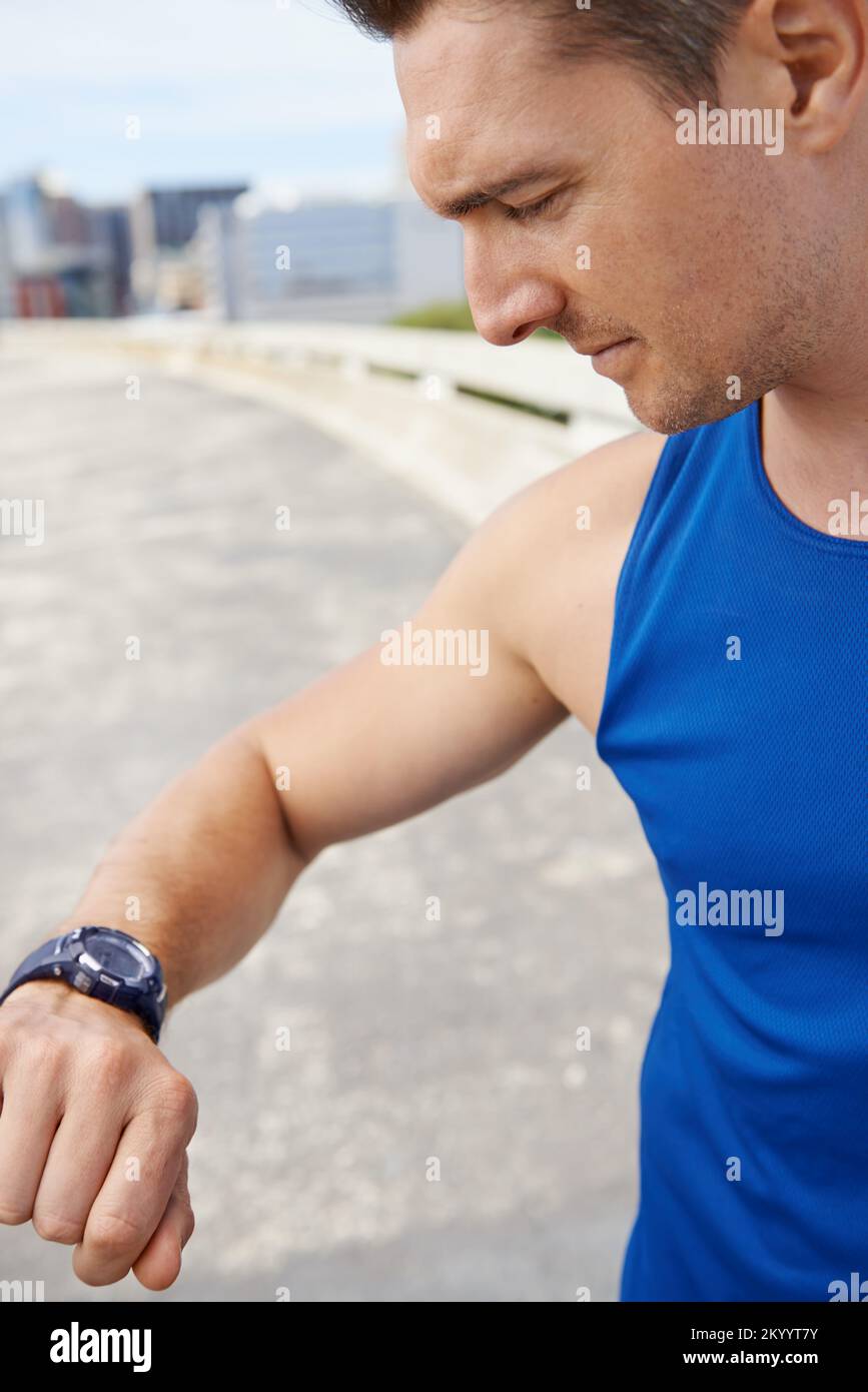Ready to beat his time. Cropped image of a male runner looking at his ...