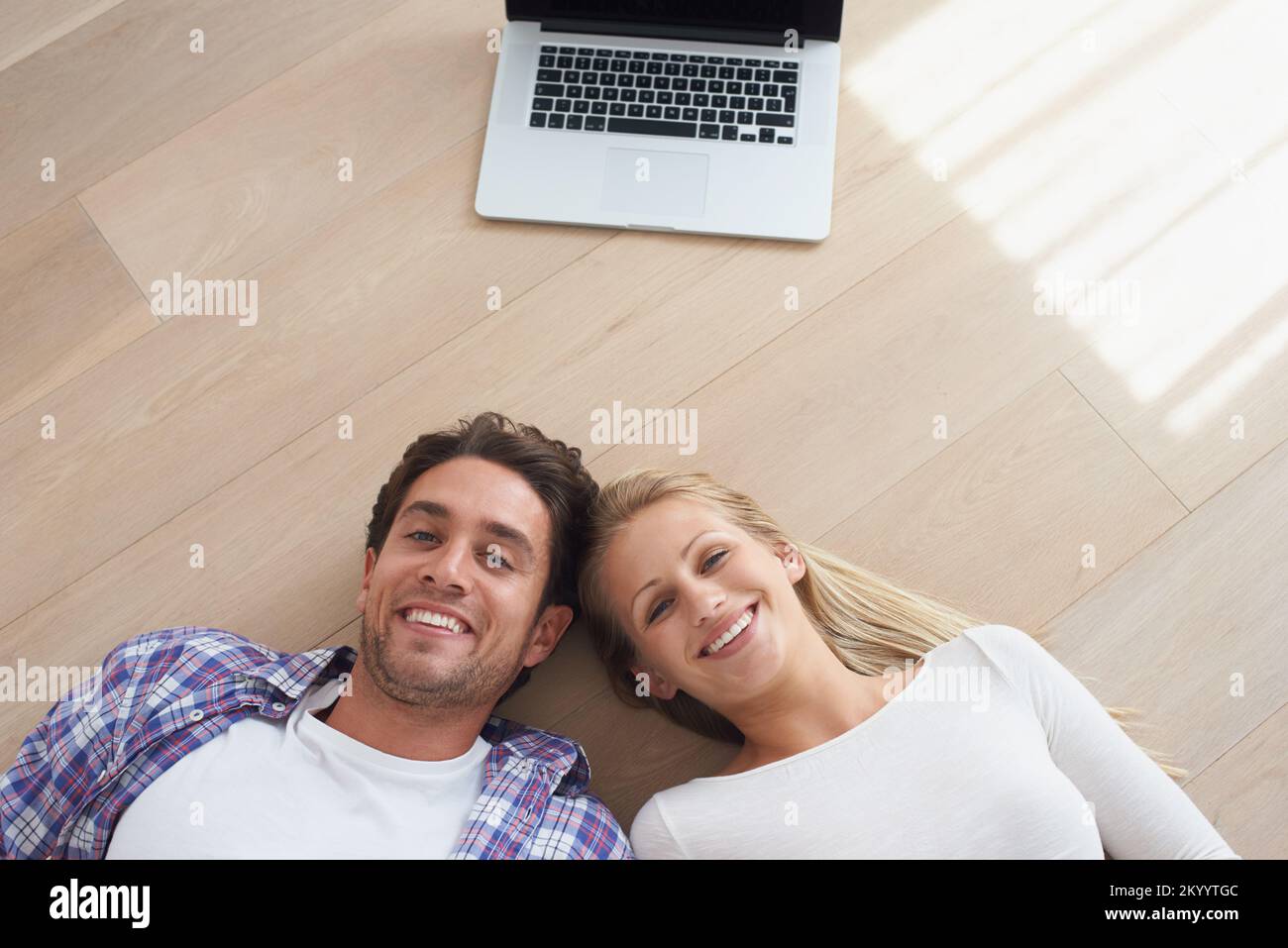 Taking things easy. A happy young couple lying on their backs on the ...