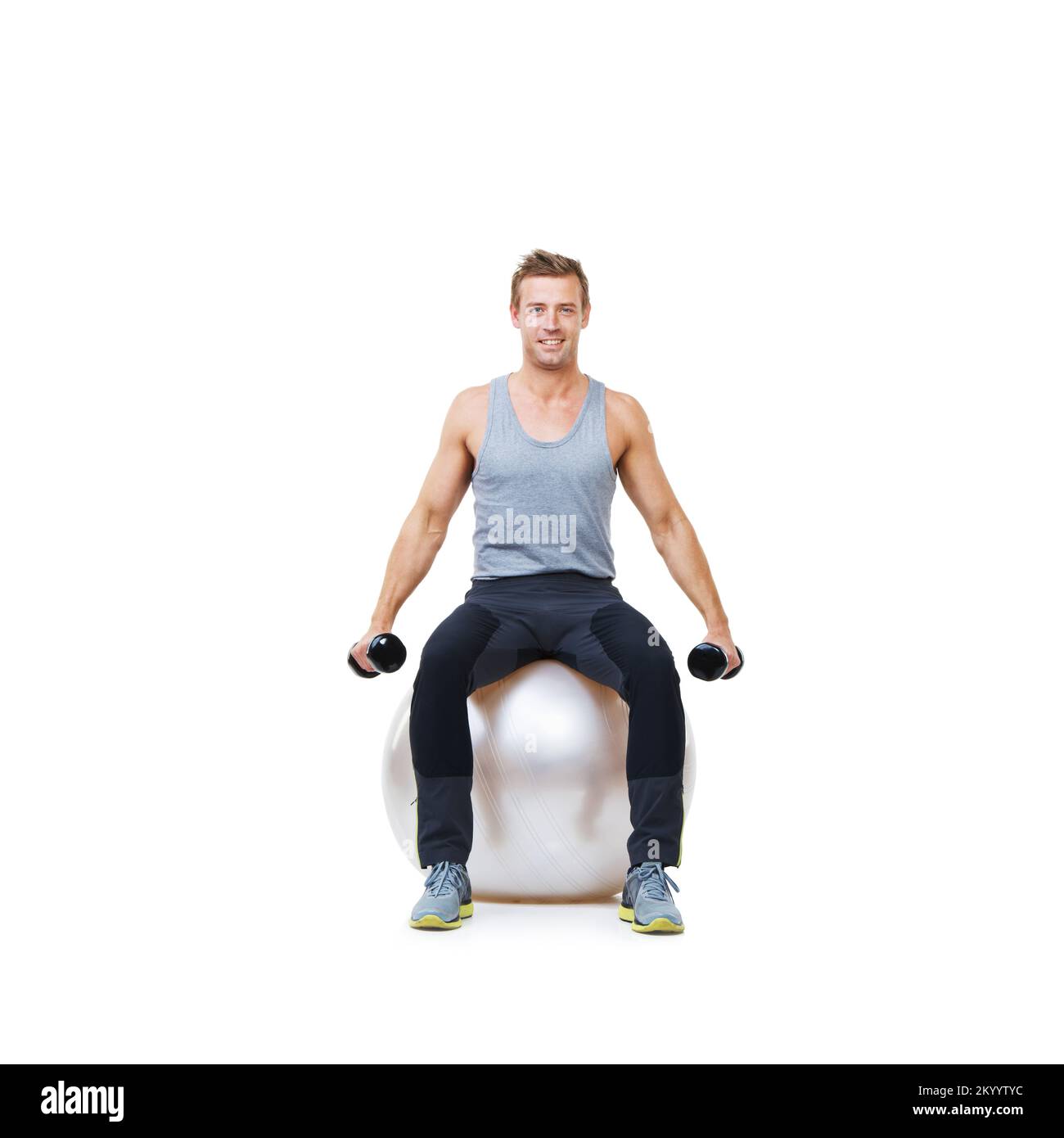 Getting in perfect shape. Portrait of a man sitting on an exercise ball ...